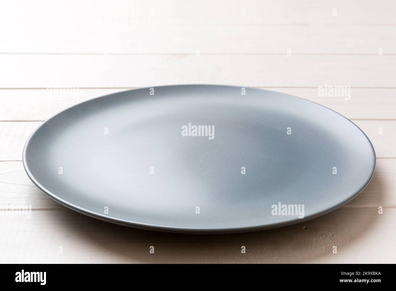 Perspective view of empty grey plate on cement background. Empty space ...