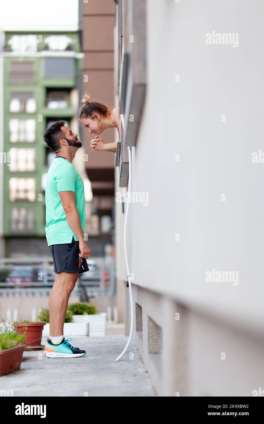 Couple in love. Boy standing outdoors talking with girl from within a ...