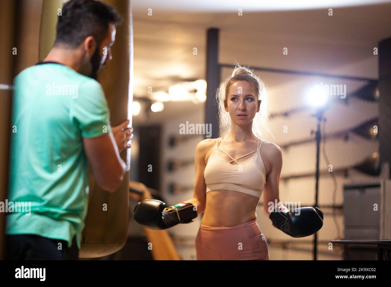 Fit girl with boxing gloves. Male fitness instructor with a female ...