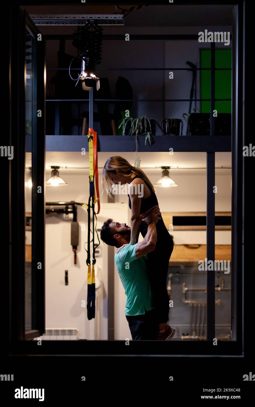 Couple in love. Boy and girl hugging in a fitness studio. View from ...