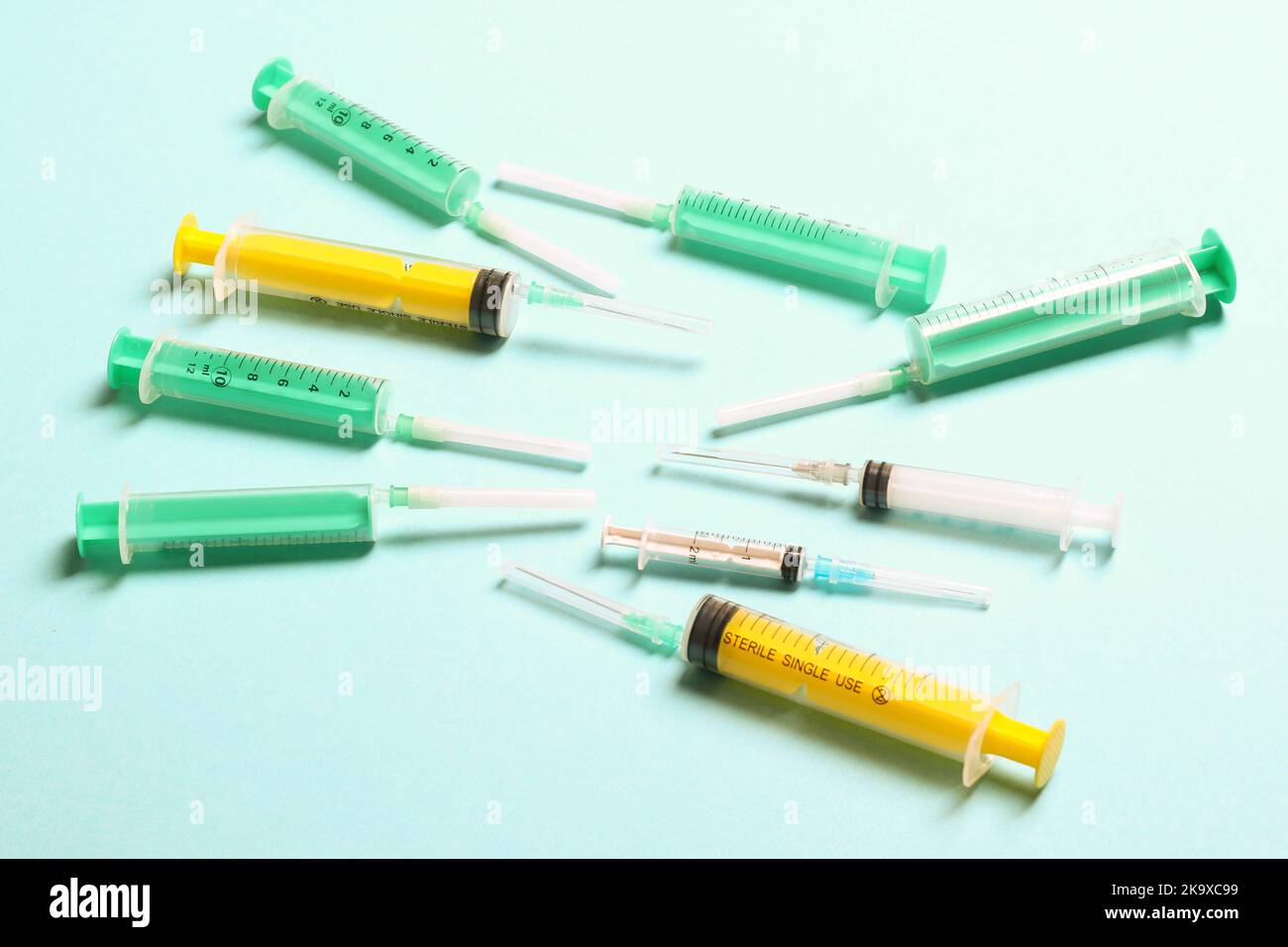 Top view of medical syringes with needles at blue background with copy ...