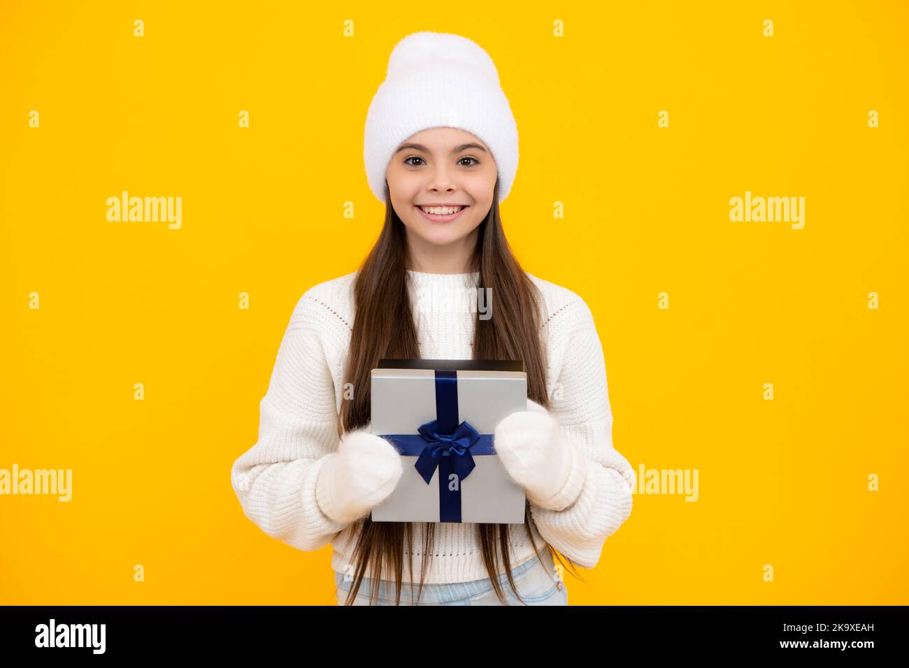Teenager child hold gift on birthday. Funny kid girl in winter wear ...