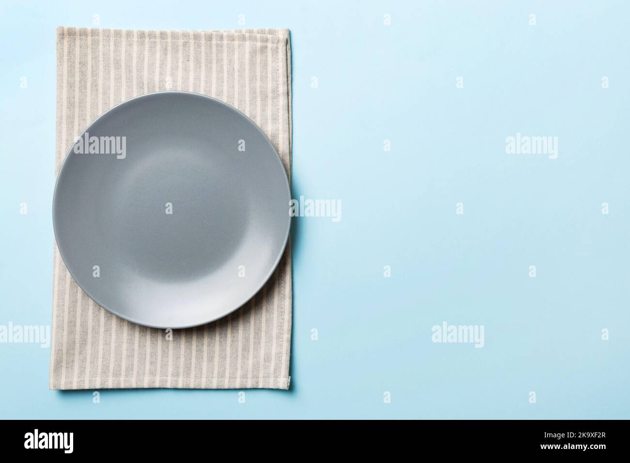 Top view on colored background empty round gray plate on tablecloth for ...