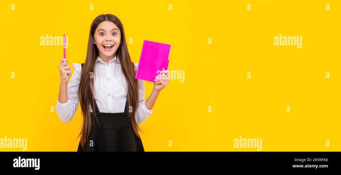 Happy girl child got idea holding book and pointing pen up yellow ...