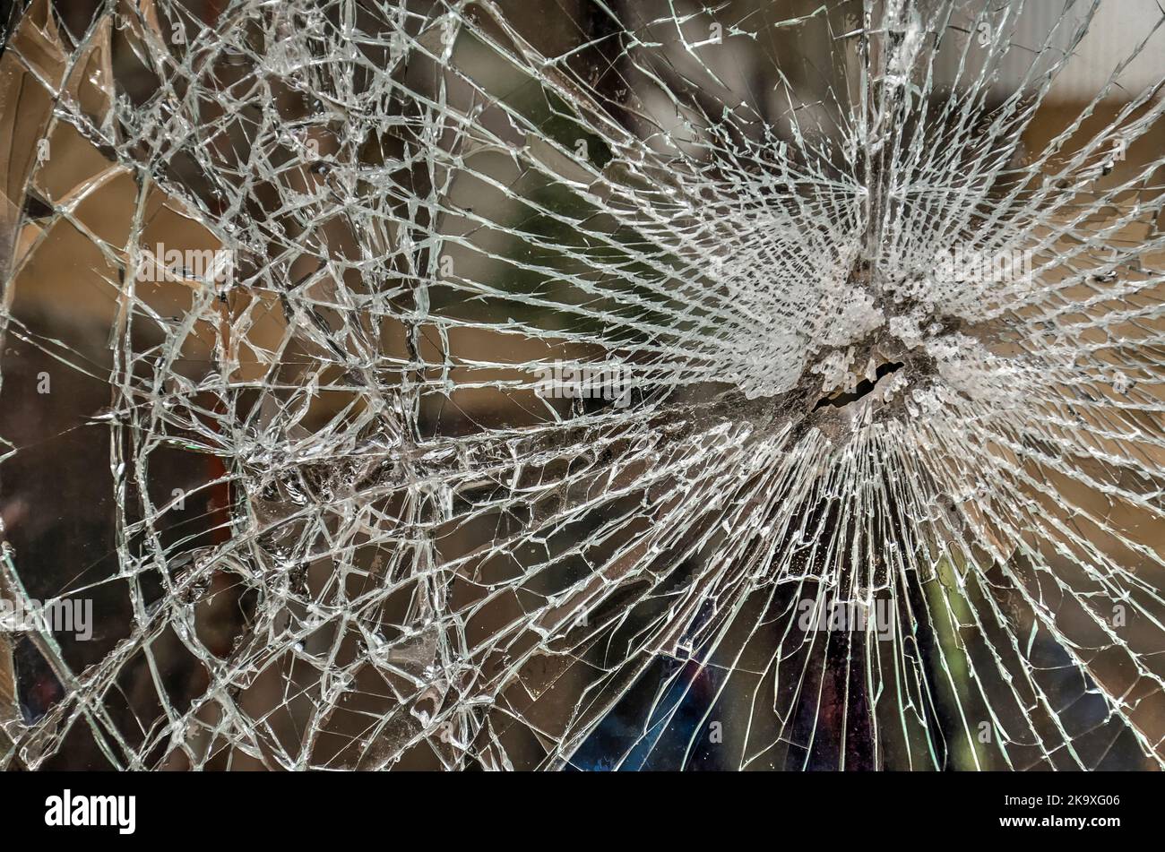 Cracks in the glass of a window that has most likely been hit a hammer ...