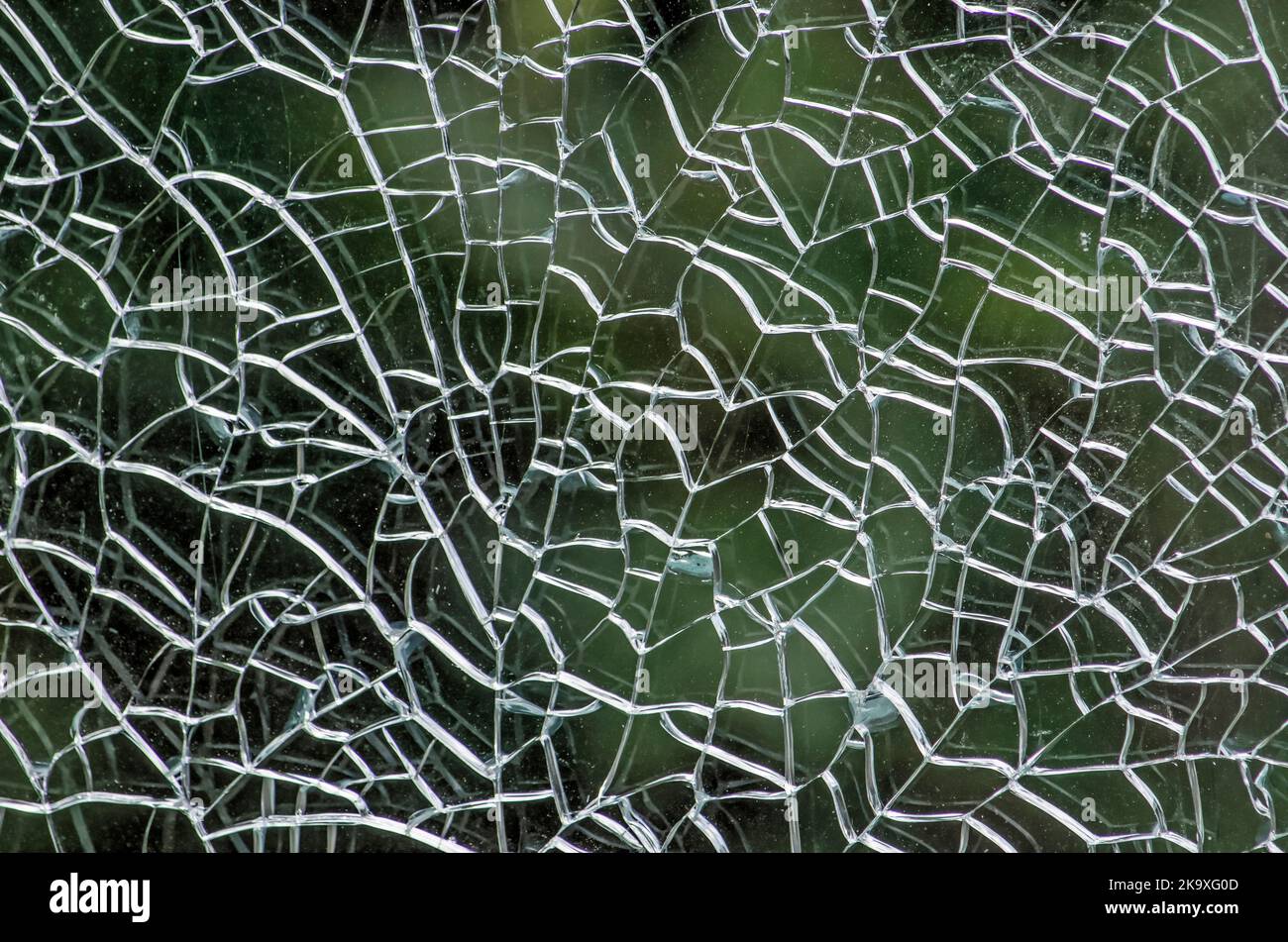 Fascinating pattern of cracks in a window with a blurred green ...