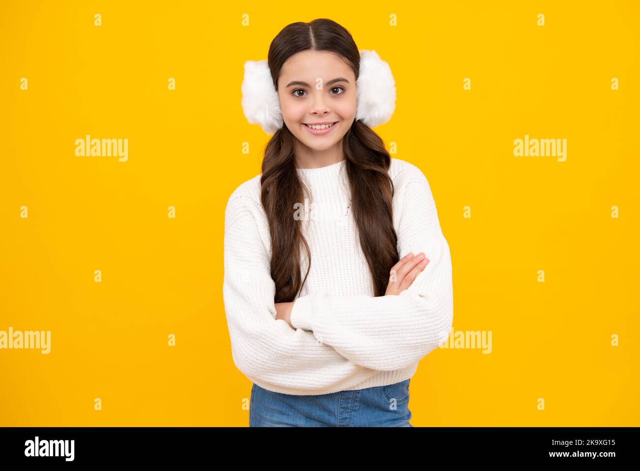 Beautiful teen girl in winter warm earmuff ear-flaps and a warm sweater ...