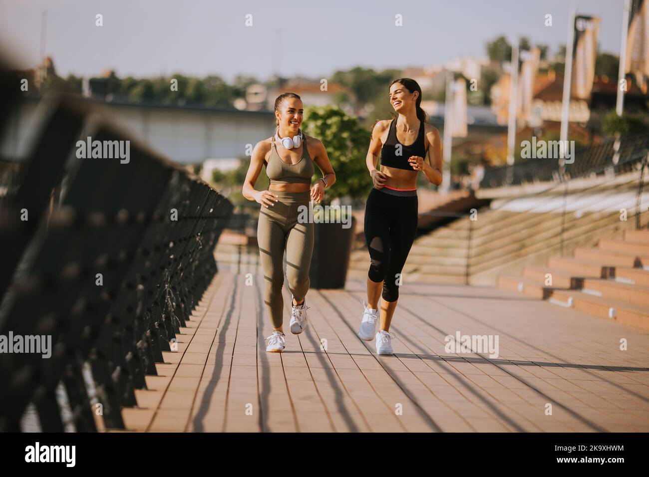 Pretty young woman taking running exercise by the river promenade Stock ...