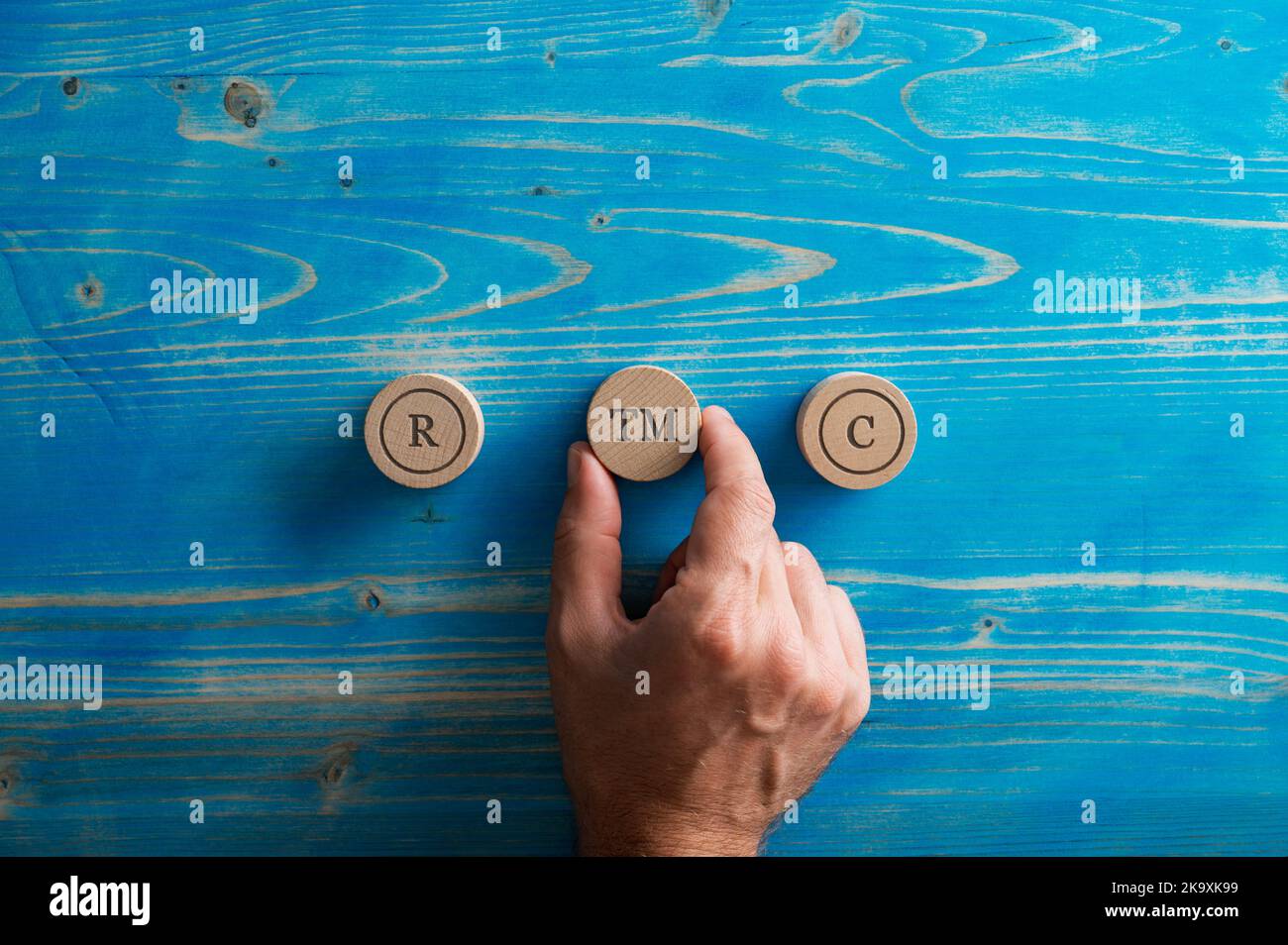 Conceptual image of trademark and copyrights - male hand placing three ... Conceptual image of trademark and copyrights - male hand placing three ...