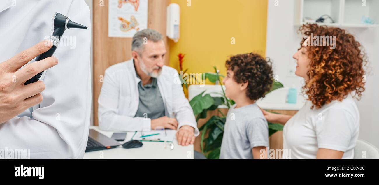 Audiologist with otoscope over background doctor consultation with ...