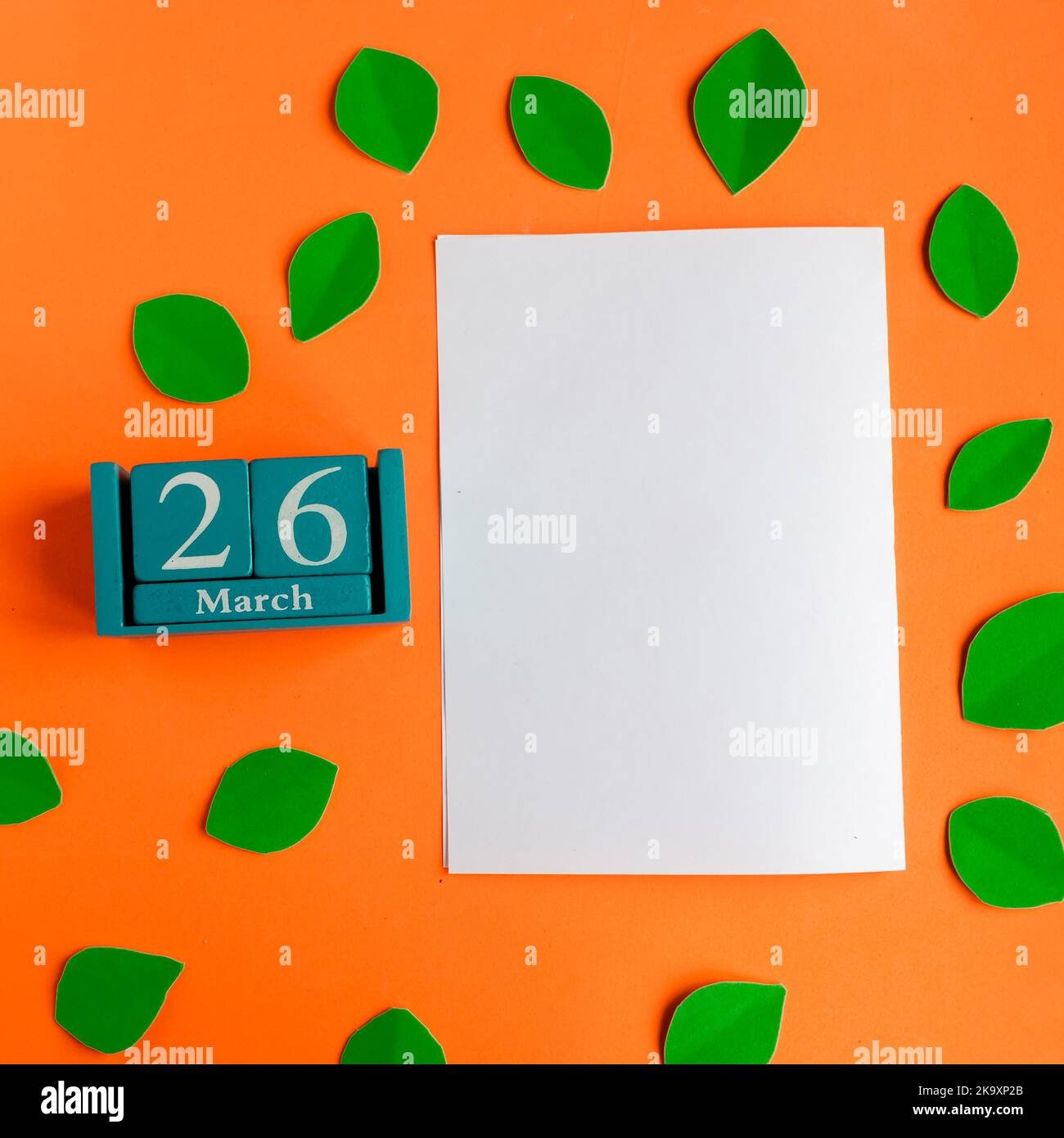 March 26. blue cube calendar and white mockup blank on bright orange ...