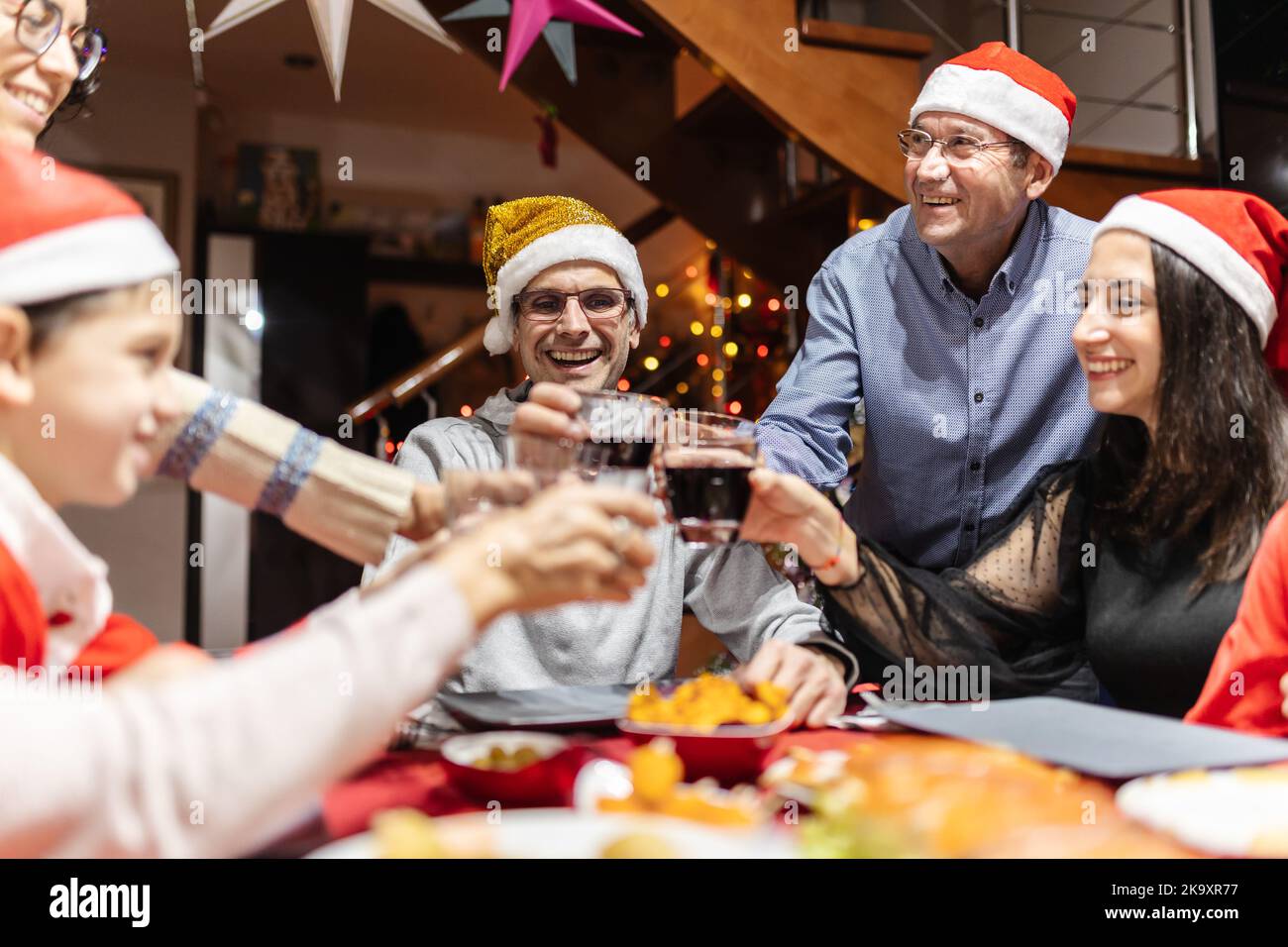 Happy family cheering with wine having fun together at christmas dinner ...