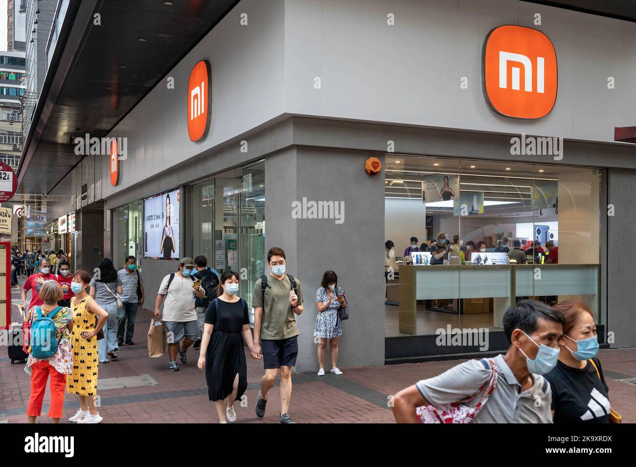 Pedestrians walk past the Chinese multinational technology and ...