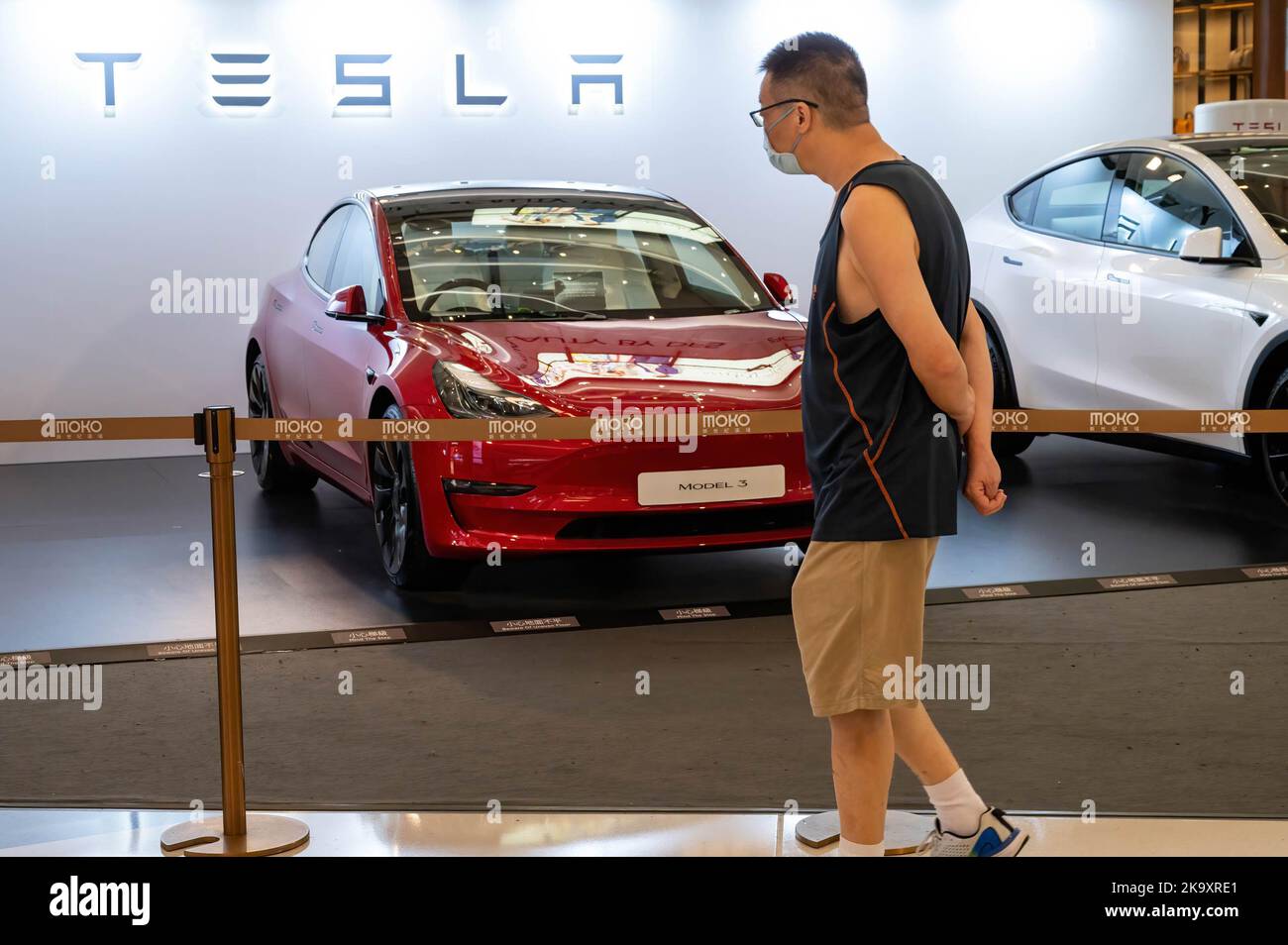 A shopper stands in front of the American automaker company, Tesla ...