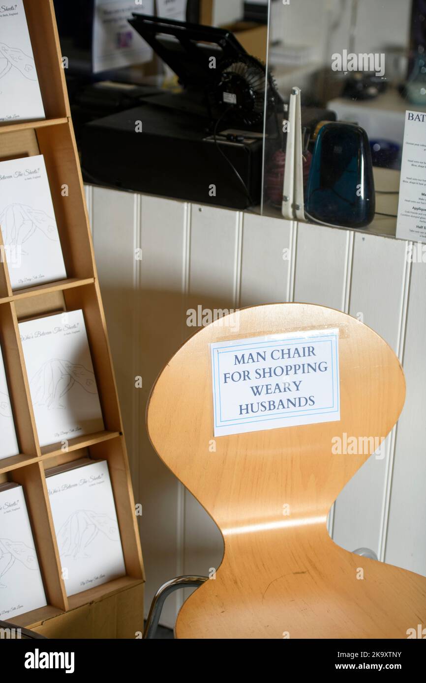 Seat in a shop humourously labelled as being for tired men Stock Photo ...