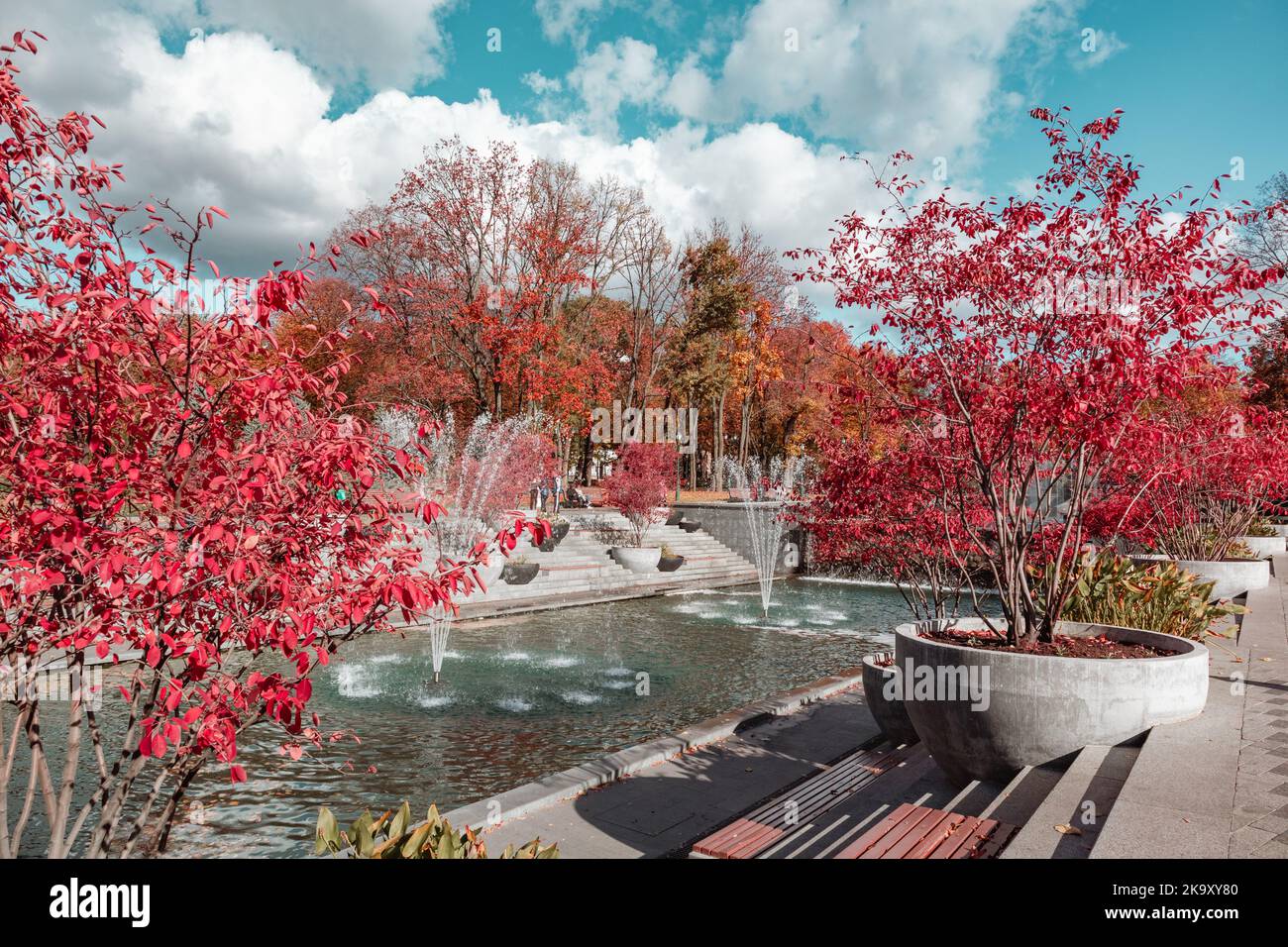 Red autumn trees and fountains in recreation area in Shevchenko City ...
