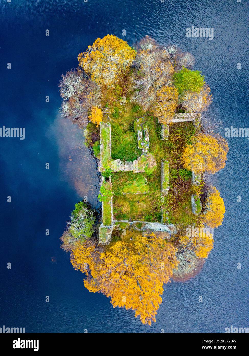 Aerial view of autumn colours and cloud reflections at ruined castle on ...