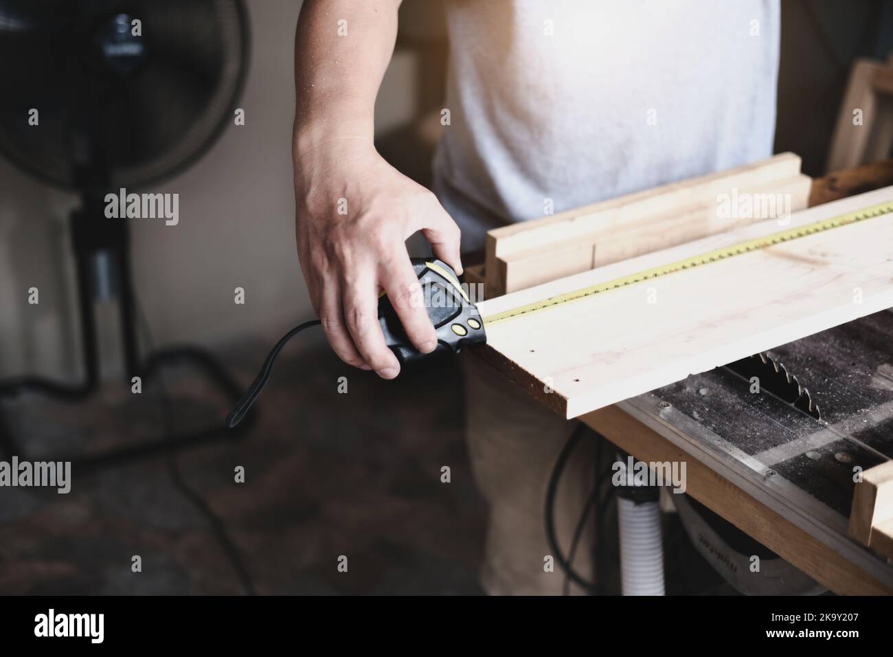 do-it-yourself concept Craftsmen use a tape measure to assemble wooden ...
