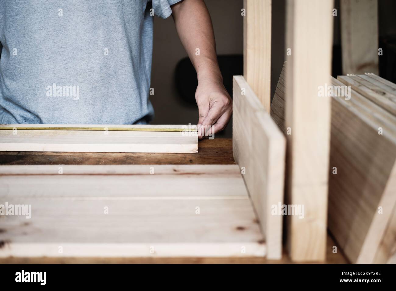 do-it-yourself concept Craftsmen use a tape measure to assemble wooden ...