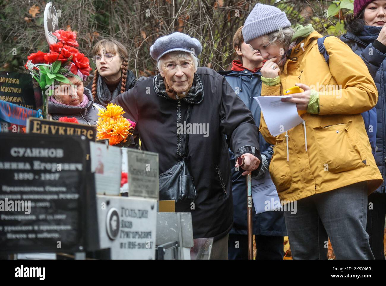 People reading names of victims and placing candles at the 'common ...