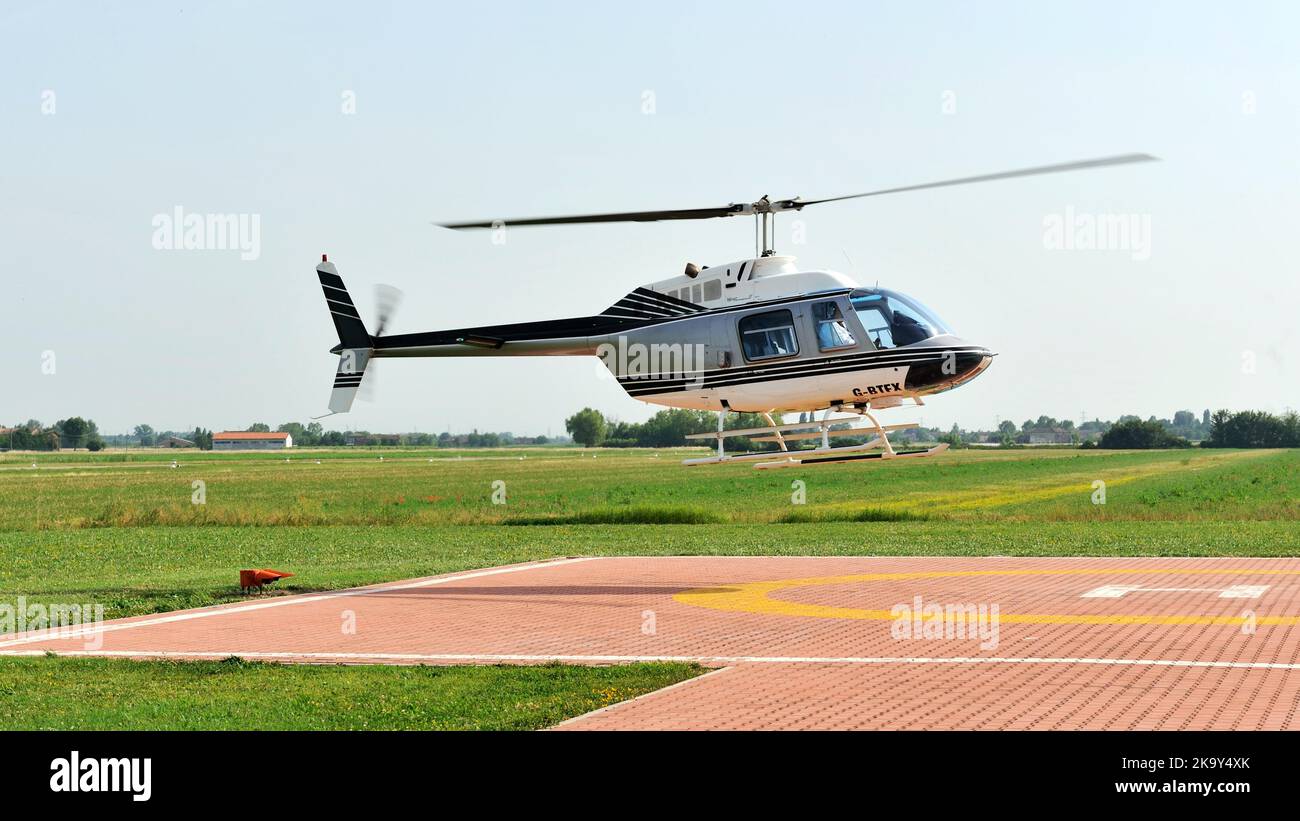 Helicopter Bell-206 Jet Ranger landing on a helicopter take-off runway ...