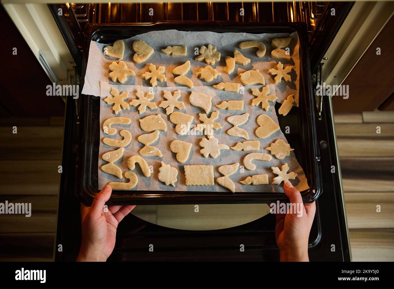 Top view: hands of a chef confectioner putting a baking sheet with ...