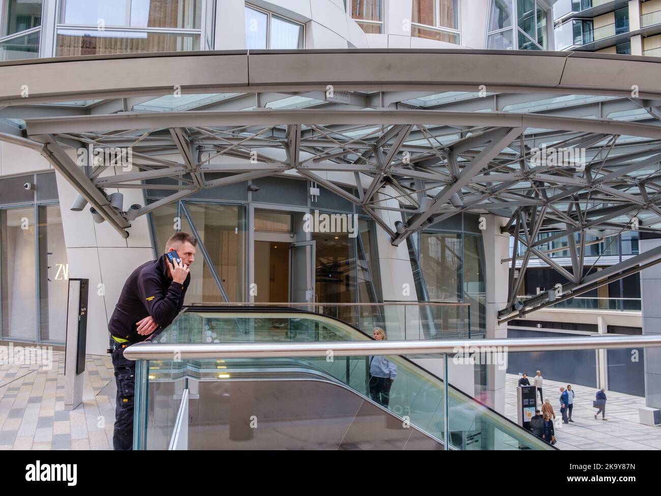 A man talks on the phone while leaning on a railing at Electric ...