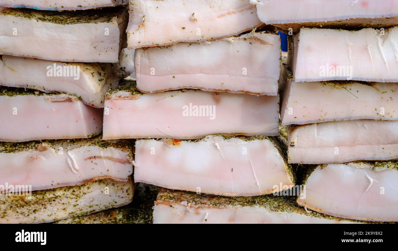 Large chunks of fresh salted bacon on the counter of a village market ...