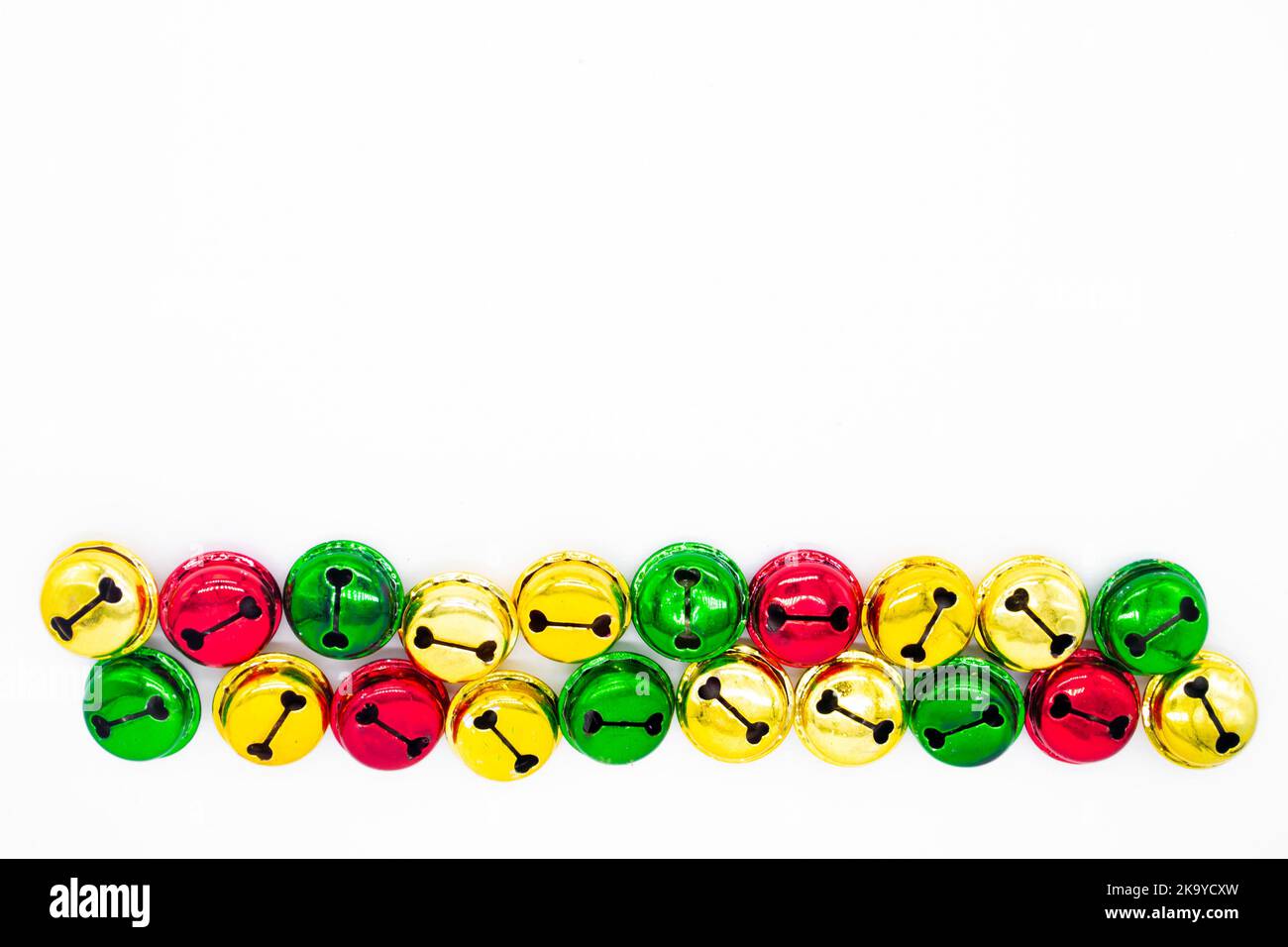 Colorful ringing Christmas bells in gold, red and green lie in a row ...