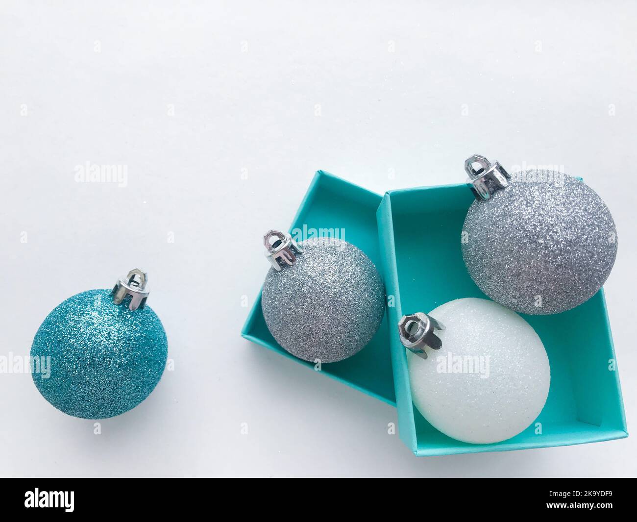 Close up of turquoise jewel boxes inside of which is a shiny Christmas ...