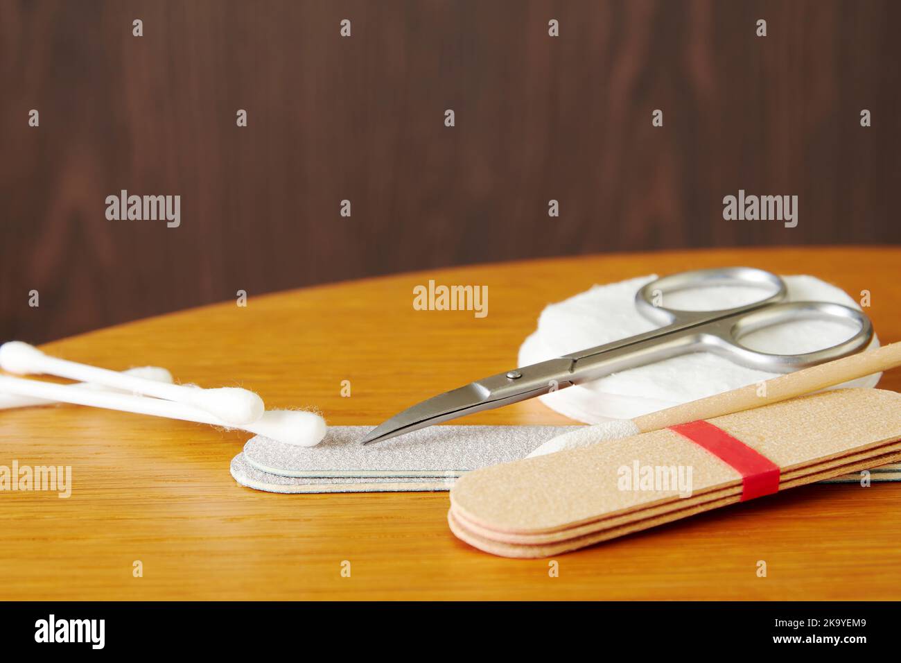 Manicure tools, scissors, nail file, cotton swab on the wooden table ...
