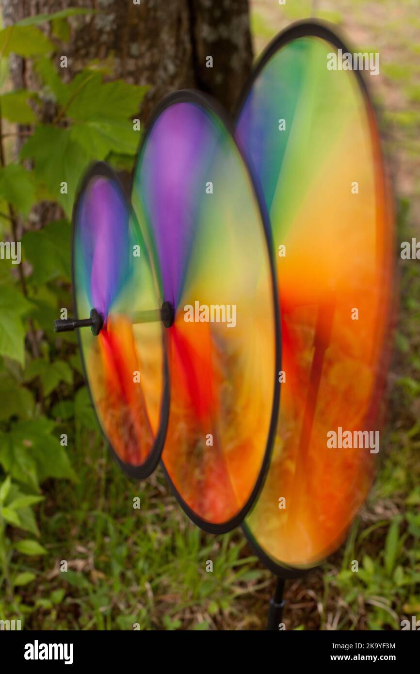 Colorful triple pinwheel spinning in the wind. Round pinwheel with ...