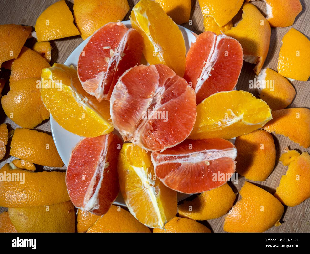 oranges and grapefruit cut into pieces on a white plate. Next to it are ...