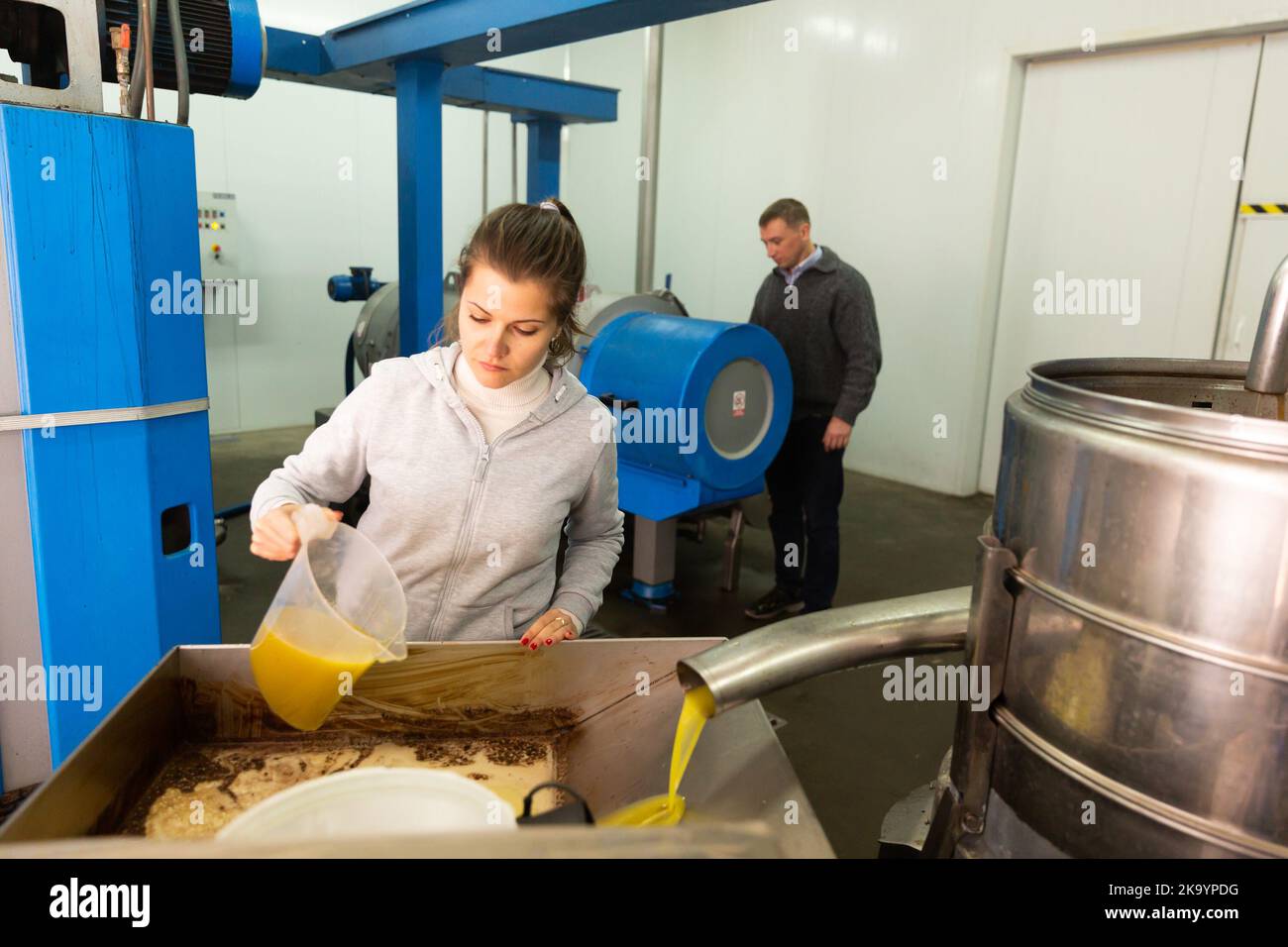 Woman controlling process of oil decanting Stock Photo - Alamy