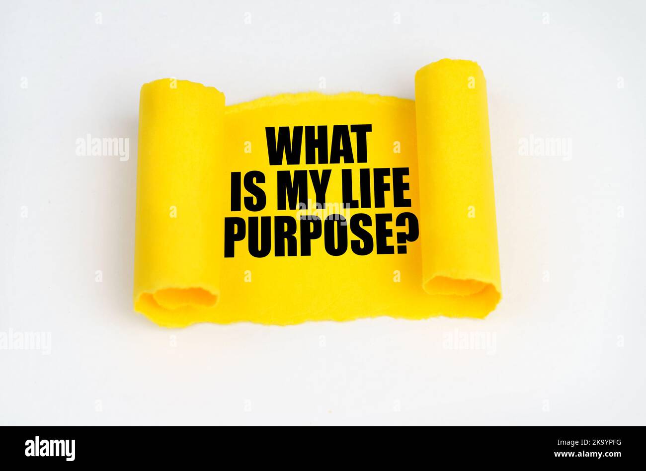 On a white surface, a yellow scroll of paper with the inscription ...