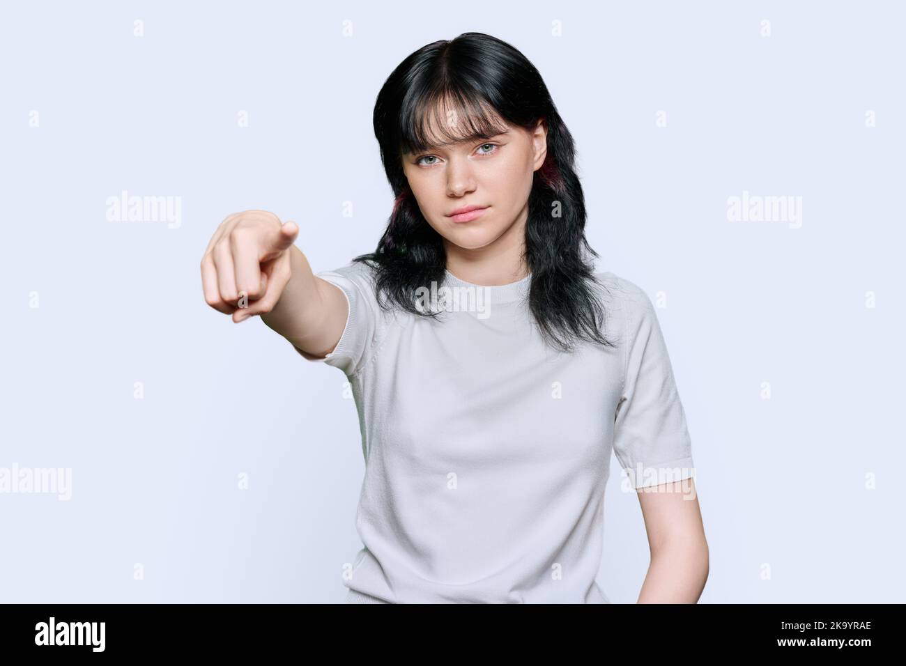 Displeased angry young woman pointing finger at camera, white ...