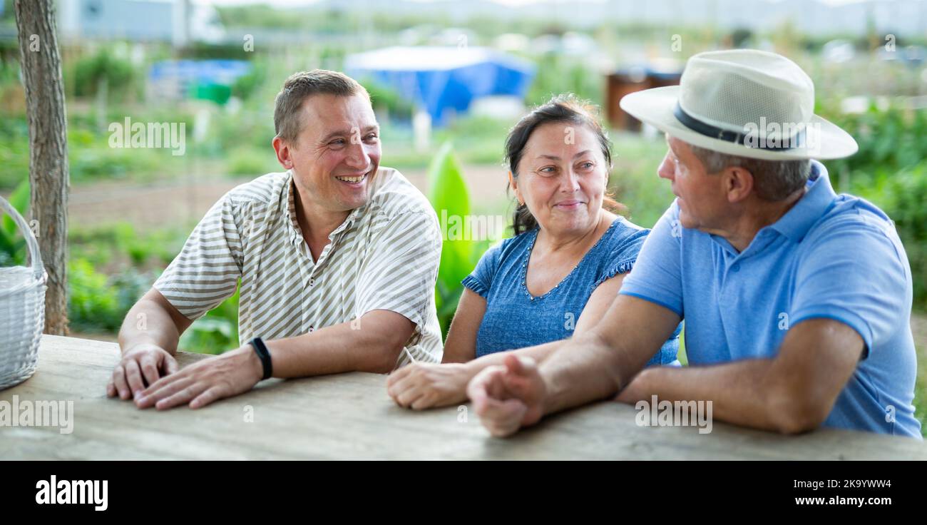 Positive family talking outdoors in backyard Stock Photo - Alamy