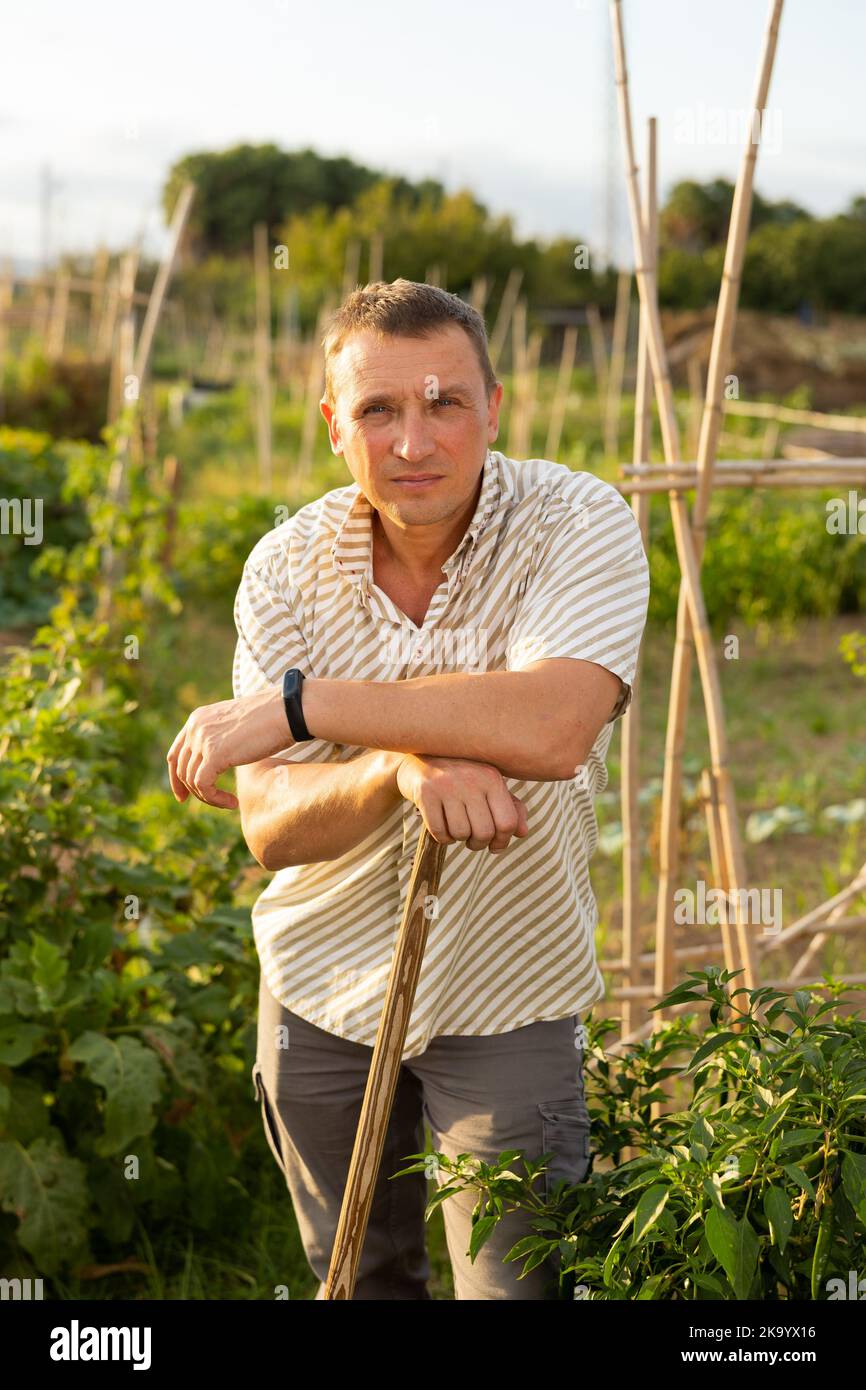 Portrait of man with working tool in backyard garden Stock Photo - Alamy