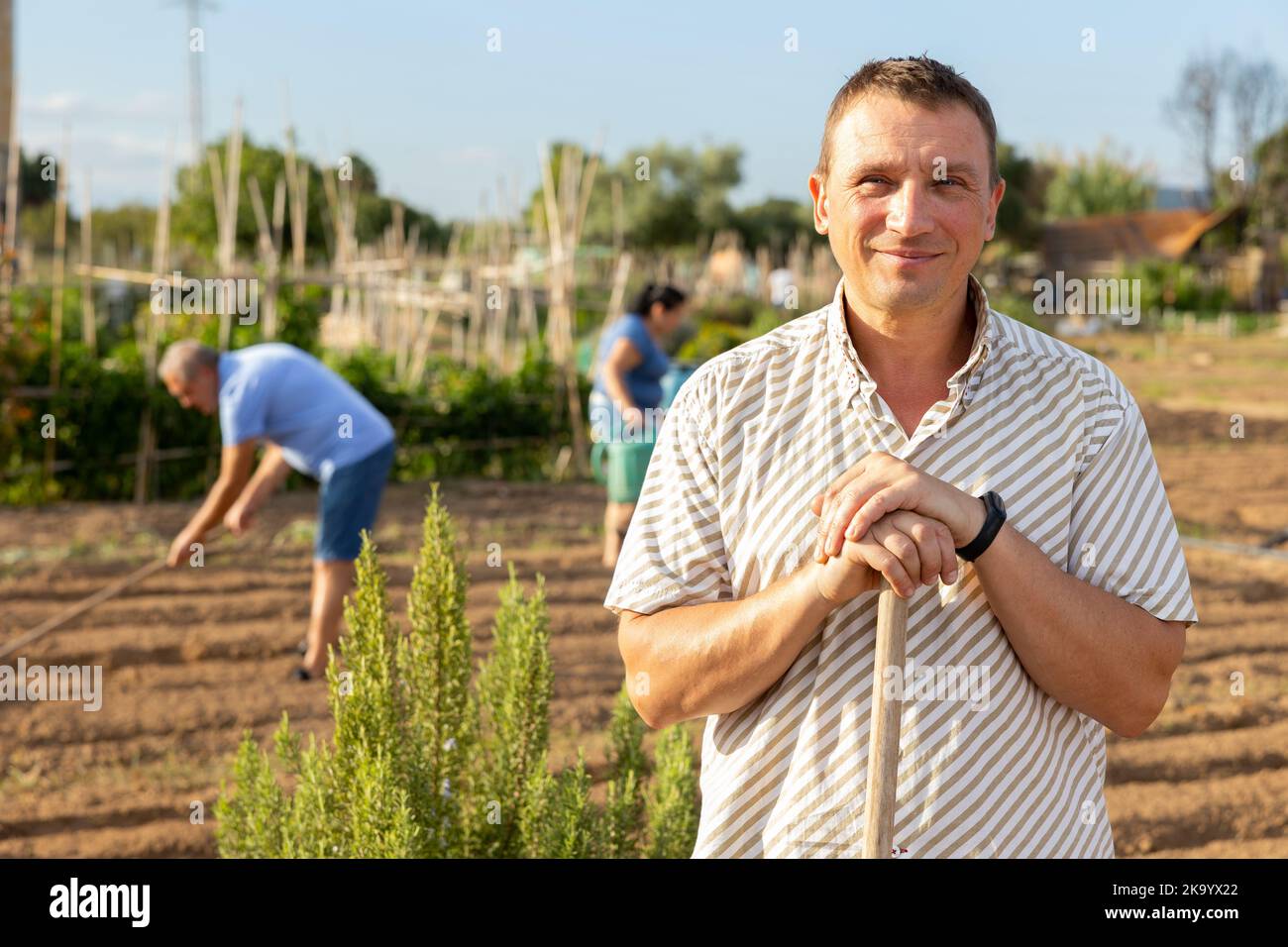 Male farmer farmer with rake standing at farm outdoor Stock Photo - Alamy