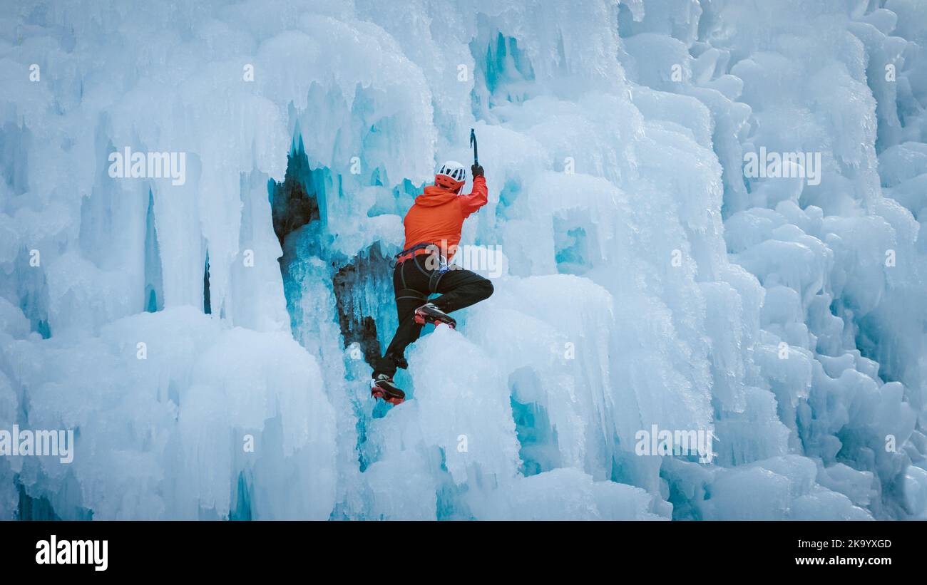 Alpinist man with ice climbing equipment on a frozen waterfall Stock ...