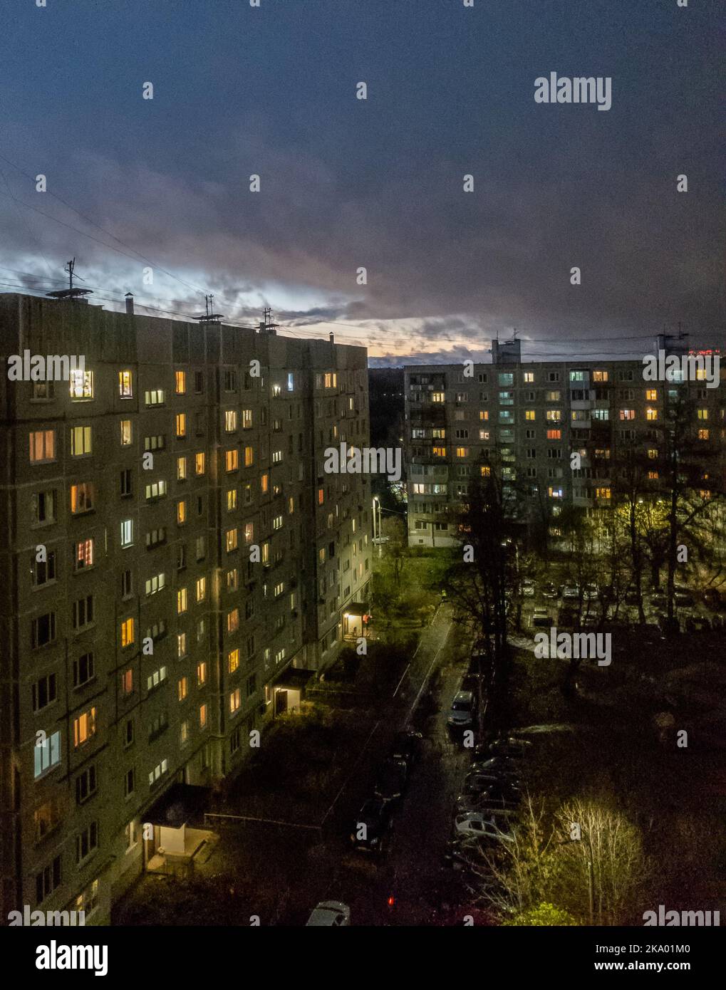 Evening and yellow lights in the windows of residential buildings in ...