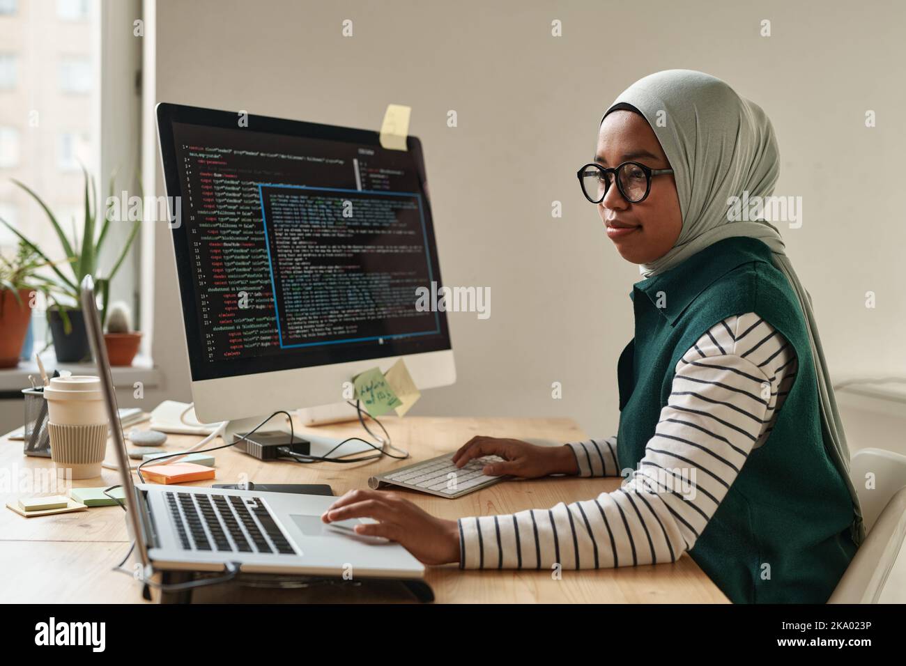 Side view of young intern or professional software developer touching ...