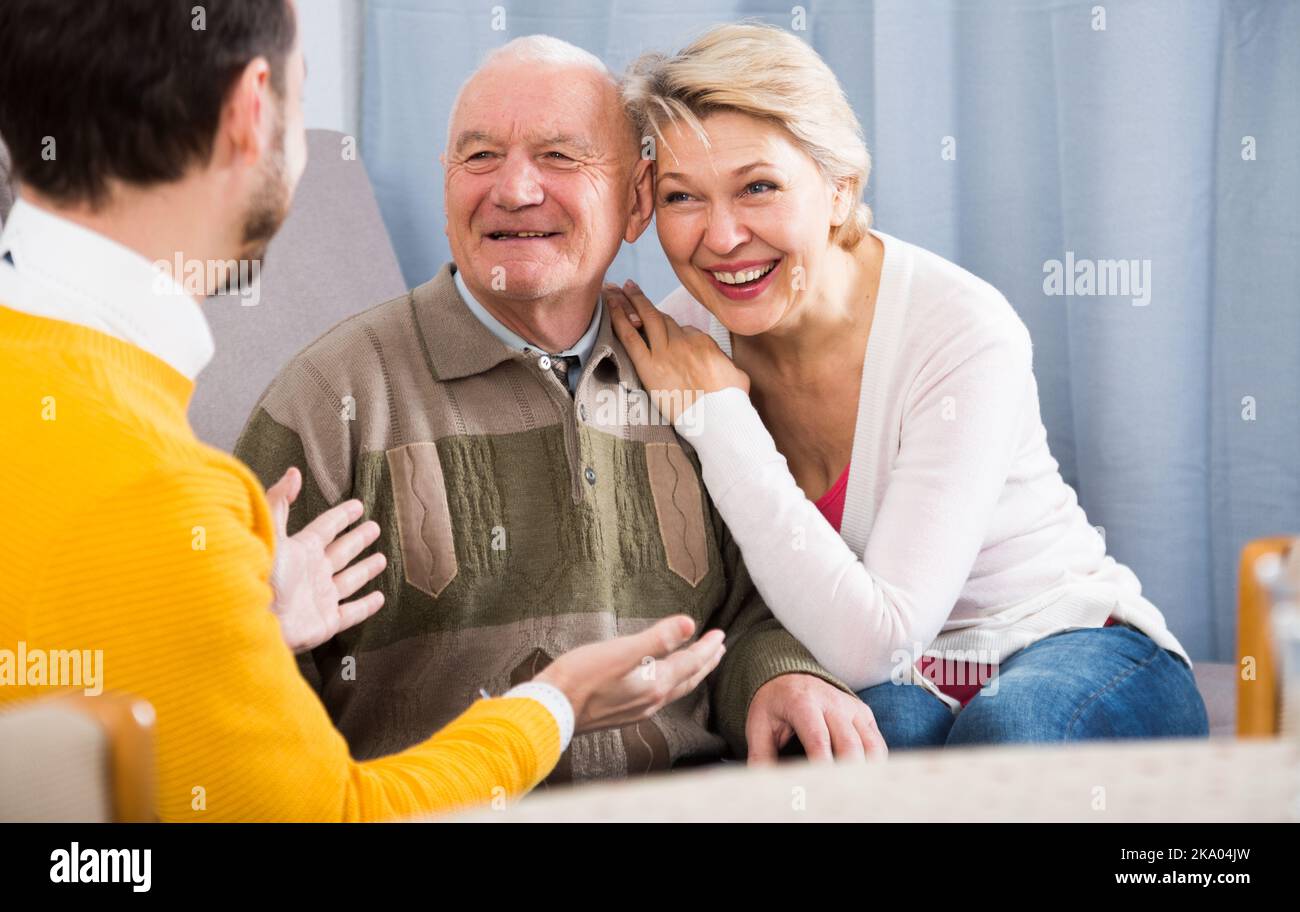 Family joyfully talking at home Stock Photo - Alamy