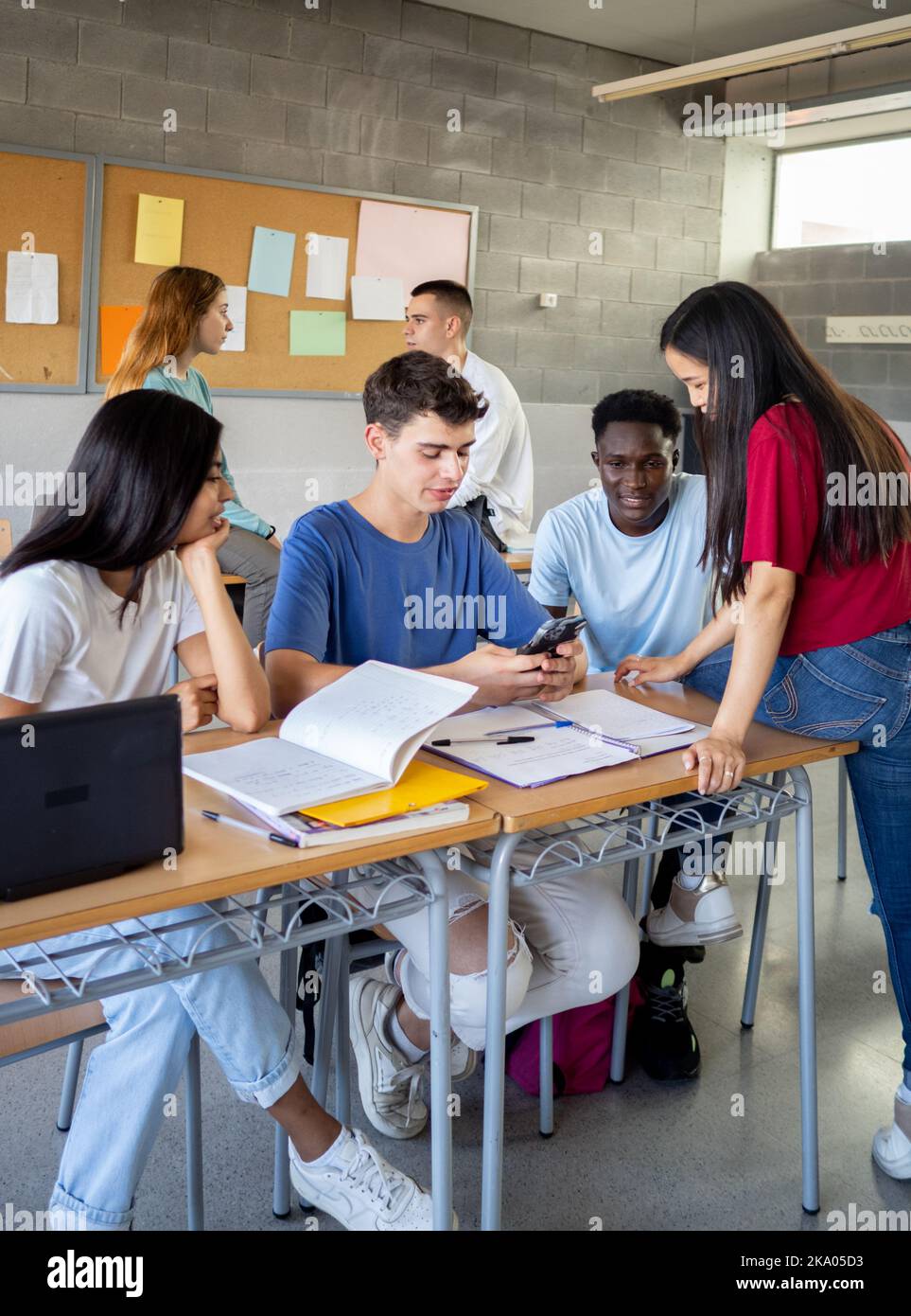 Group of multi-ethnic students talking in class during a break. High ...
