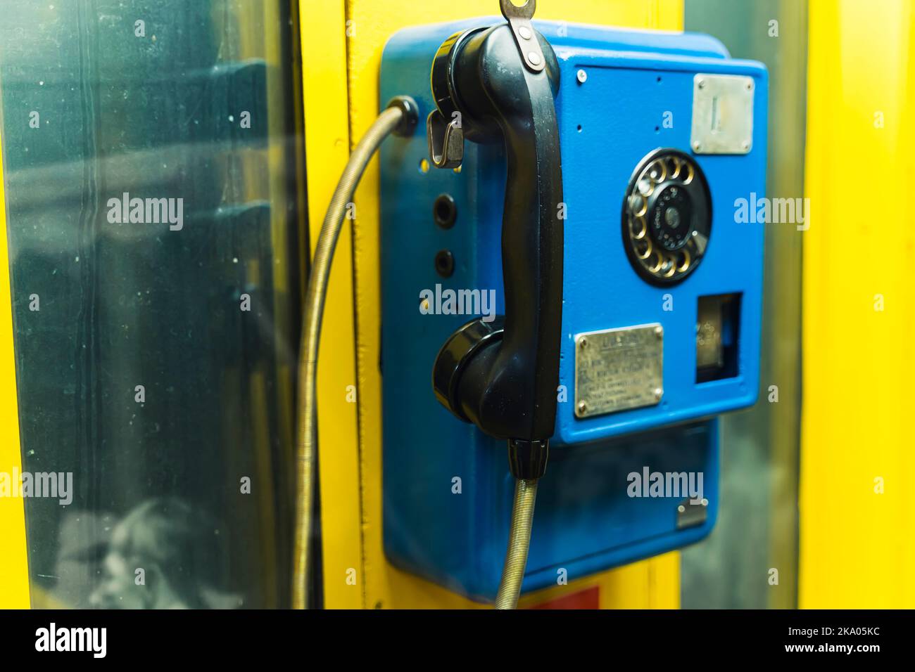 Vintage old-fashioned bright yellow phone booth with dark blue ...