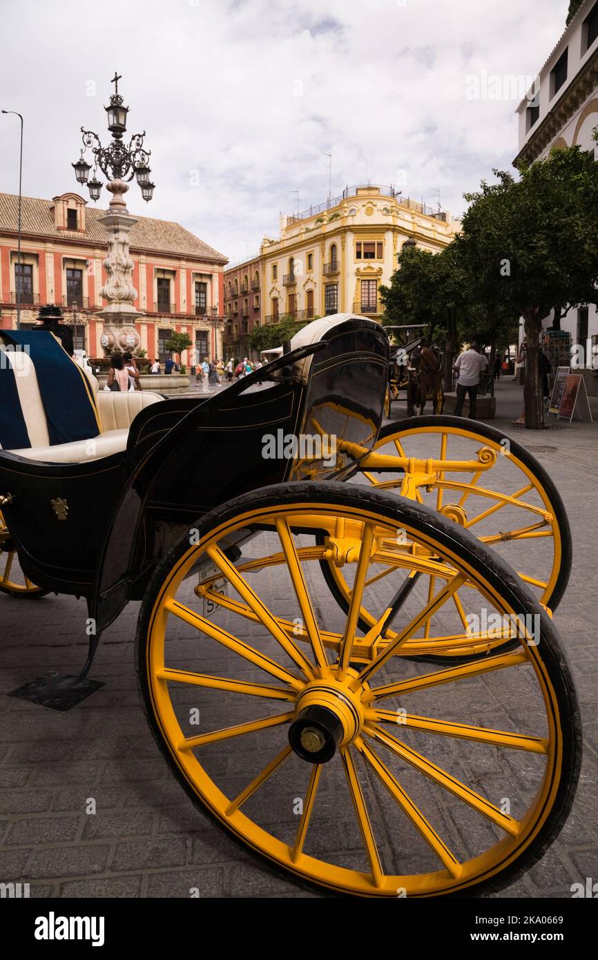 Parked black and yellow horse-drawn carriage and old architectural ...