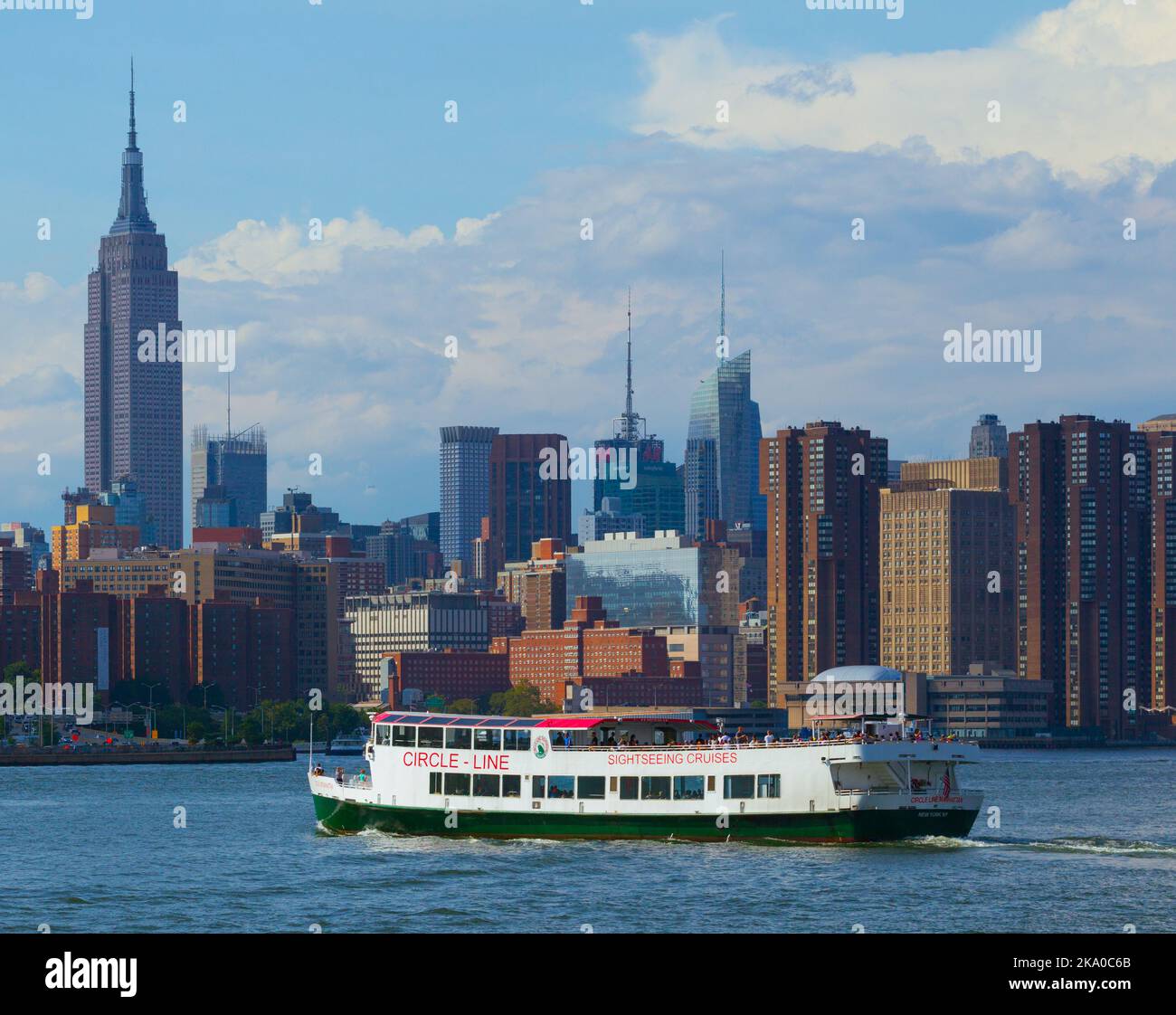 A Circle Line ferry on the East River, with the Empire State Building ...