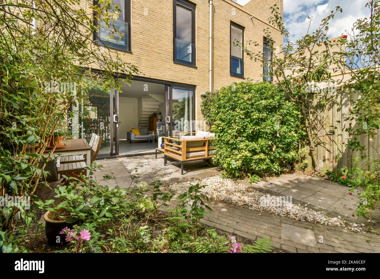 Neat powerful patio with sitting area and small garden near wooden ...