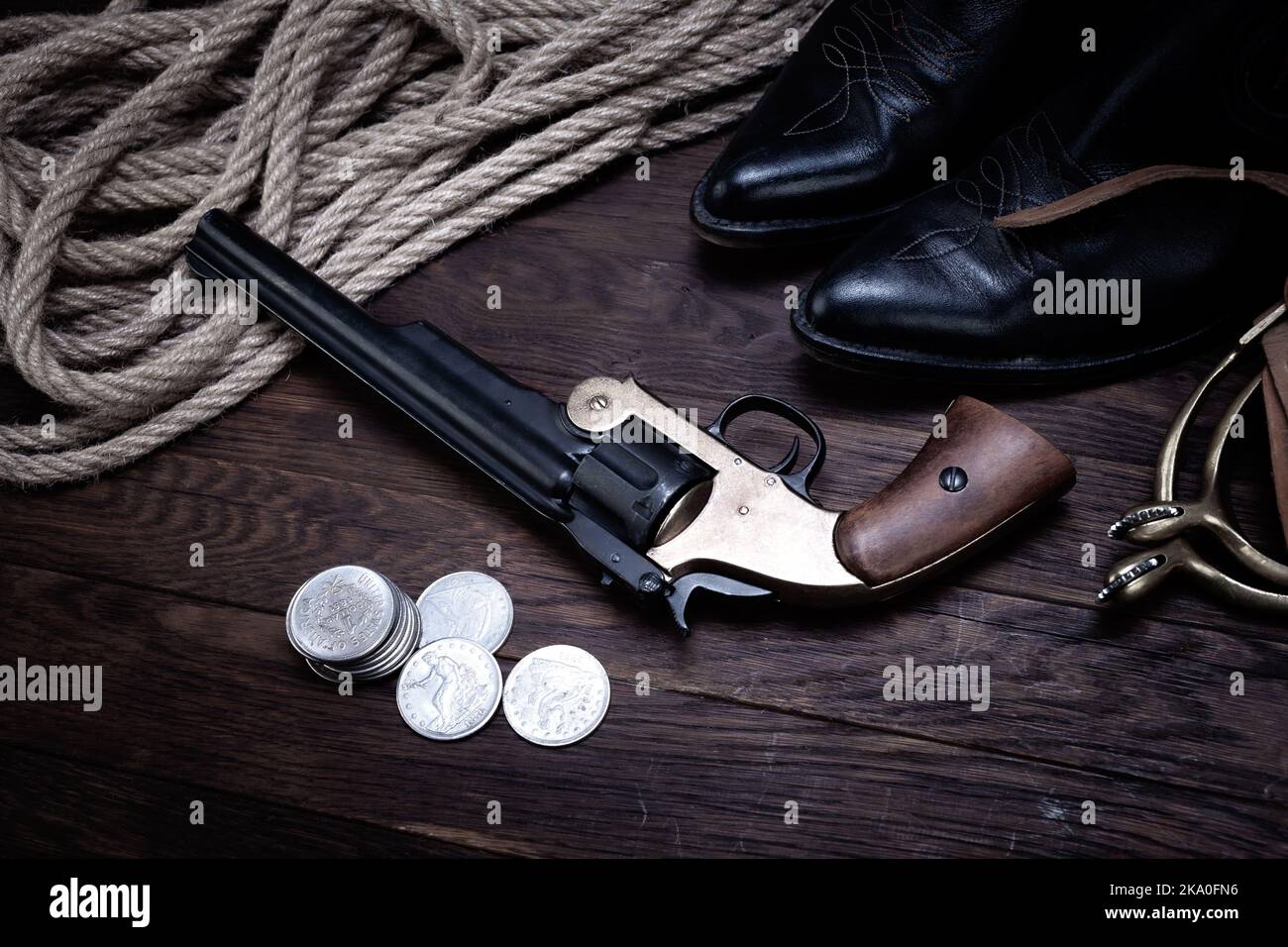 Old west revolver gun with silver dollars with hat, rope and cowboy ...