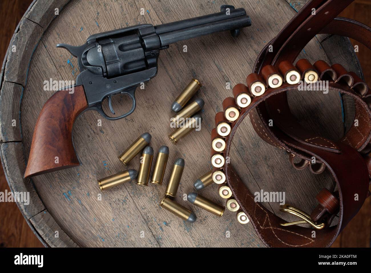 Wild west gun with belt, holster and ammunition on wooden table Stock ...
